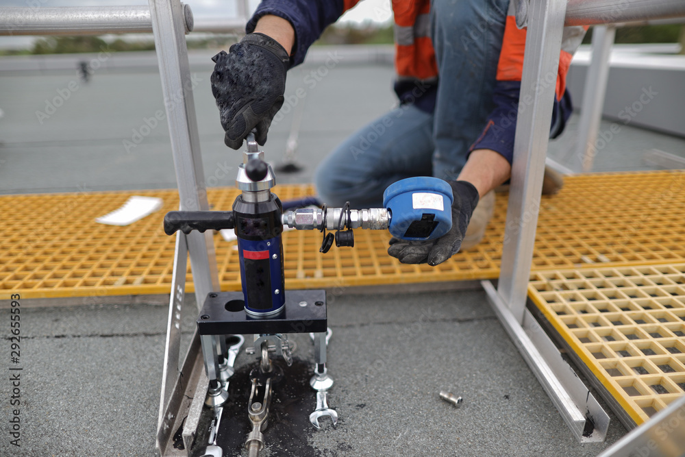 Rope access engineer conducting using pull machinery testing chemical ...