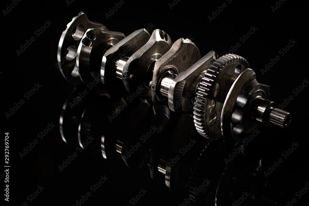 high performance racing motorcycle crankshaft on a reflective black ...