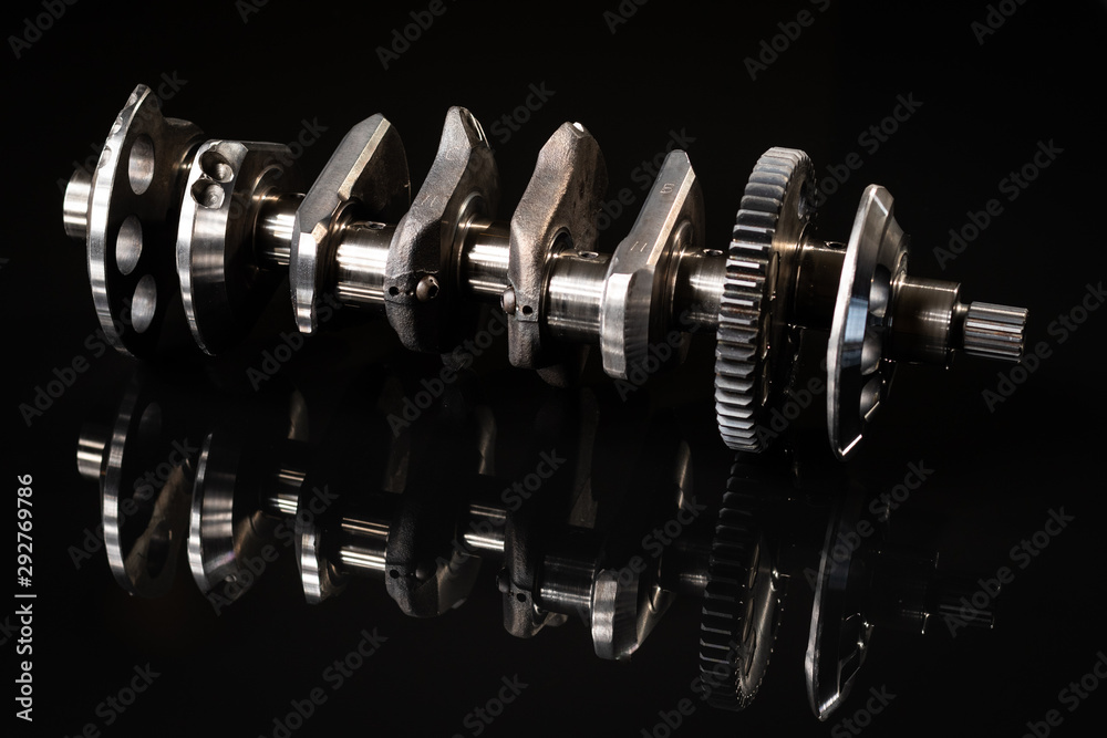 high performance racing motorcycle crankshaft on a reflective black ...