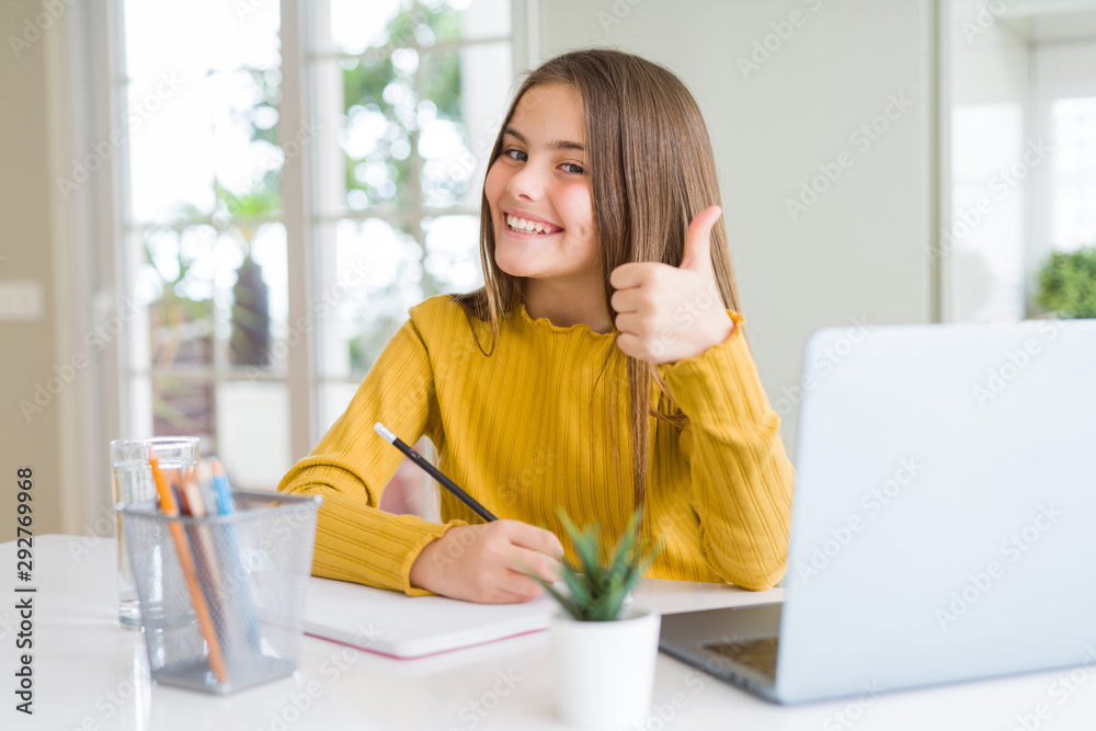 Beautiful young girl studying using computer laptop and writing on ...