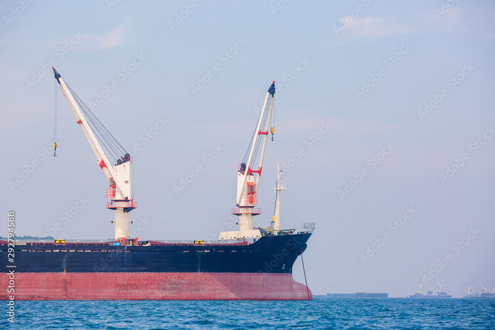 Loading goods on cargo ship with crane. Shipment from a merchant to a ...