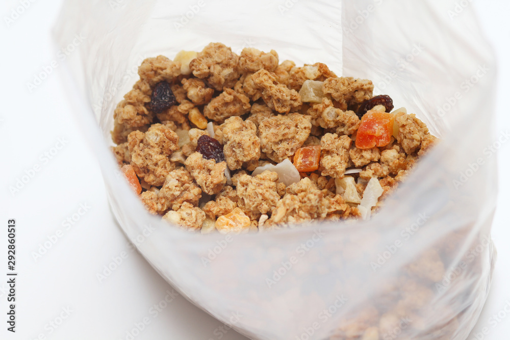 Granola with fruits and nuts in a transparent plastic bag. Baked muesli ...