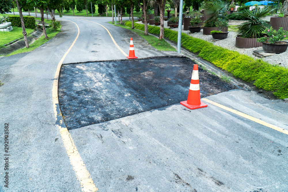 Closed damage patch asphalt road for fixing with traffic cones block in ...