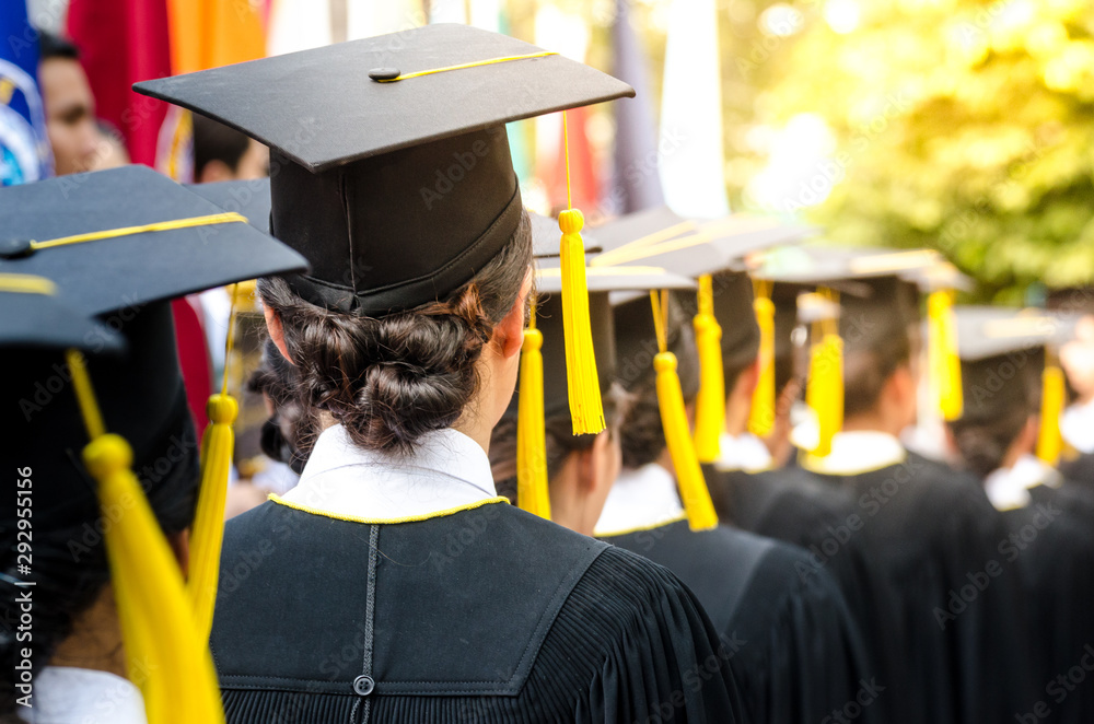 The shot of graduation hats and the back of graduates during ...