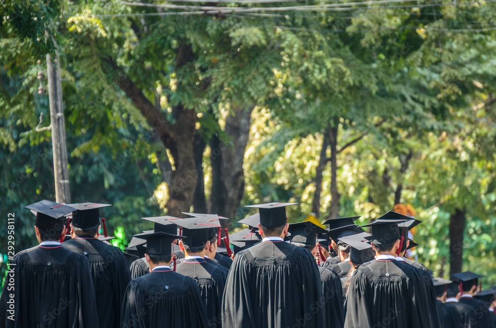 The shot of graduation hats and the back of graduates during ...