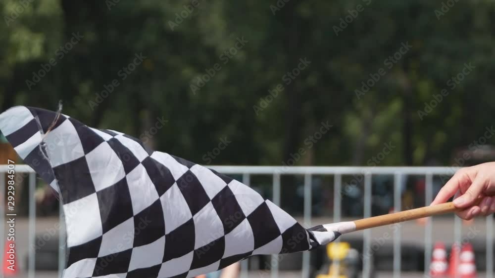 Waving checkered race flag close up. Flag which announces the final lap ...