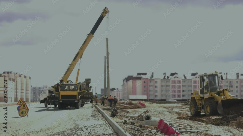 Stockvideo Workers install a pole with street light by automobile crane ...