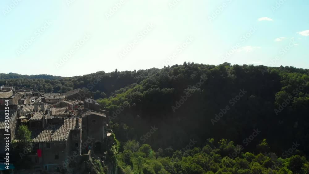 AERIAL DOLLY IN: Drone flying next to Calcata Vecchia, a typical ...