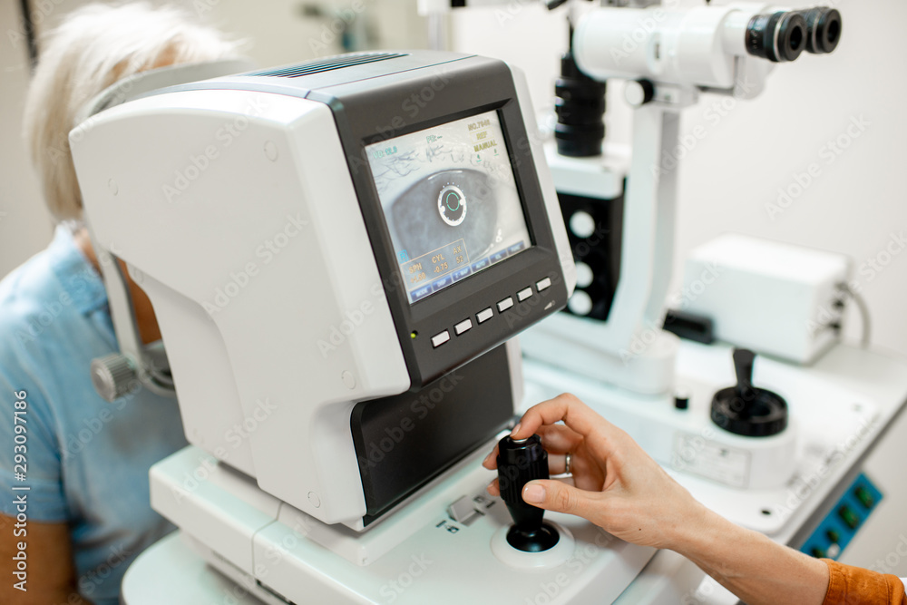 Ophthalmologist examining eyes of a senior patient using digital ...