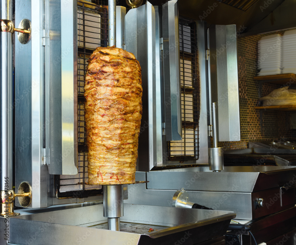 Delicious, shawarma meat cooking and turning side by side on rotating ...