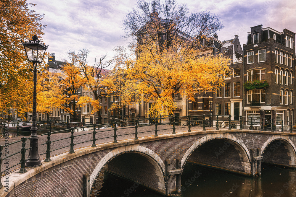Foto de Amsterdam canal with its bridges in beautiful fall colors in ...