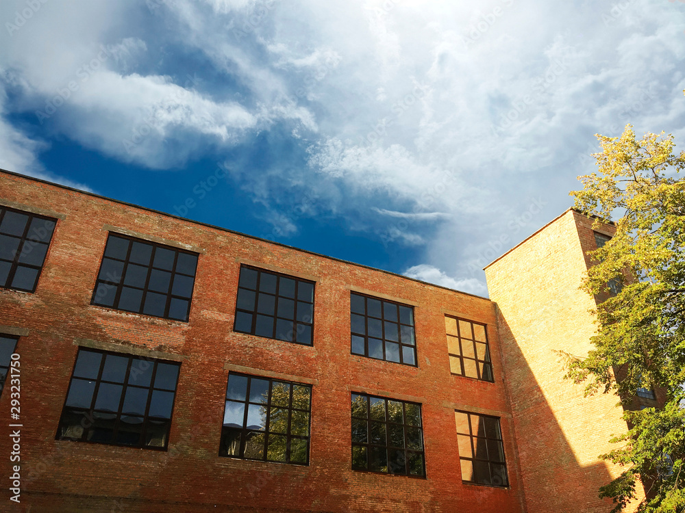 Old factory on the street. Large brick building with large windows ...