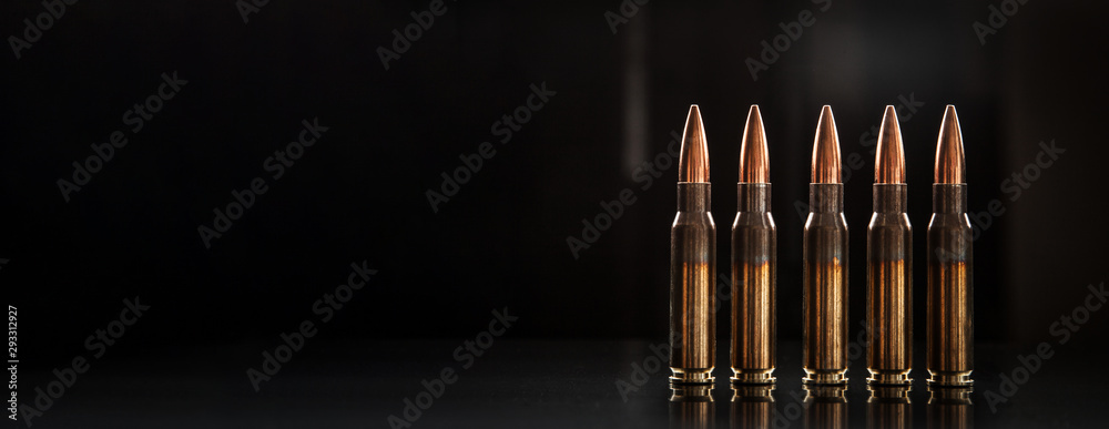 Bullet isolated on black background with reflexion. Rifle bullets close ...