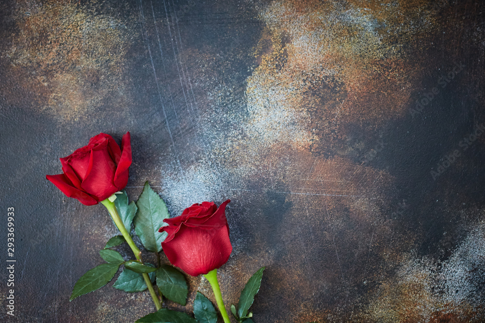 Red roses lie on a textured spotted marble background. A sign of ...