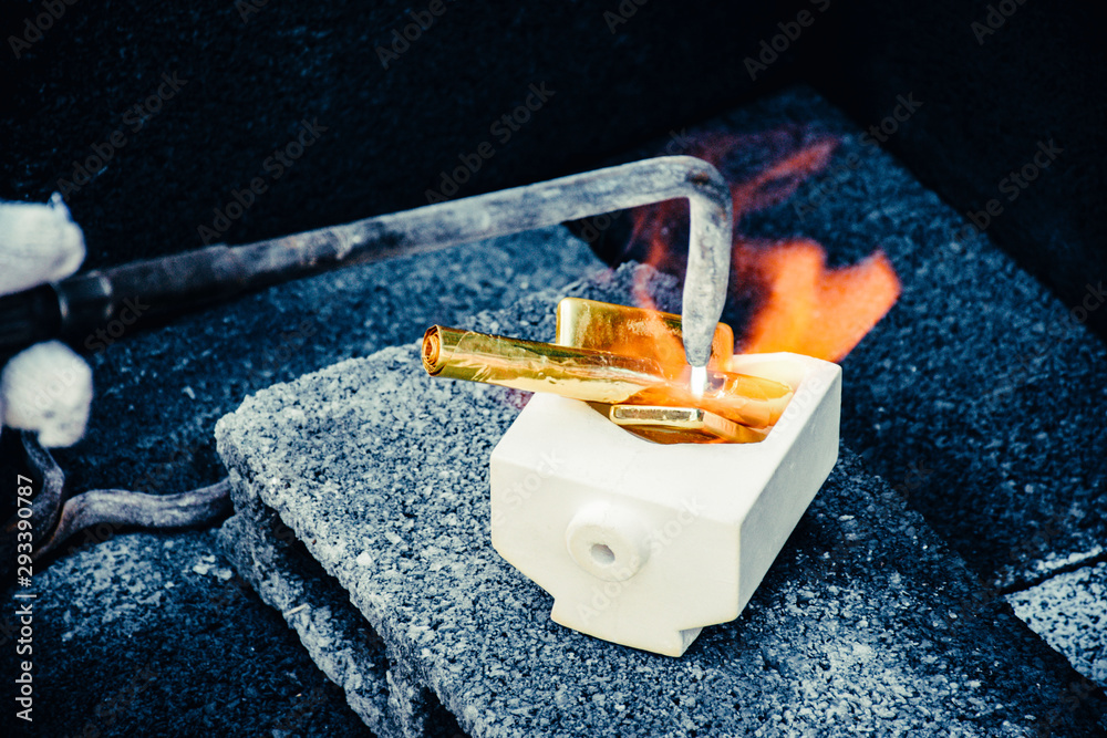 Pure Gold in the crucible is melted by heat fire from gas nozzle. Stock ...