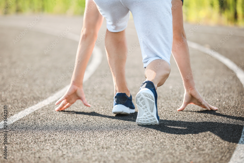 Sporty young man in crouch start position at the stadium Stock Photo ...