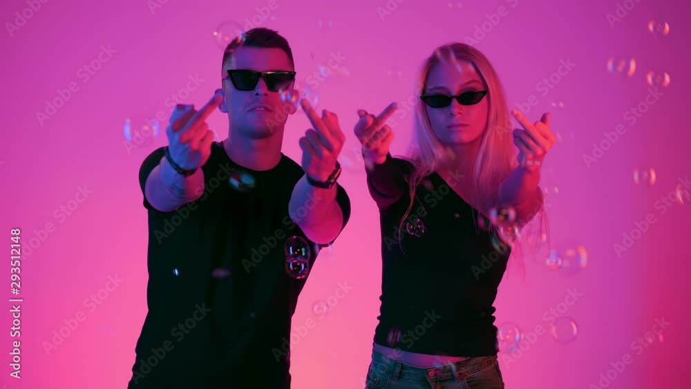 Portrait of beautiful couple wearing black and sunglasses showing ...