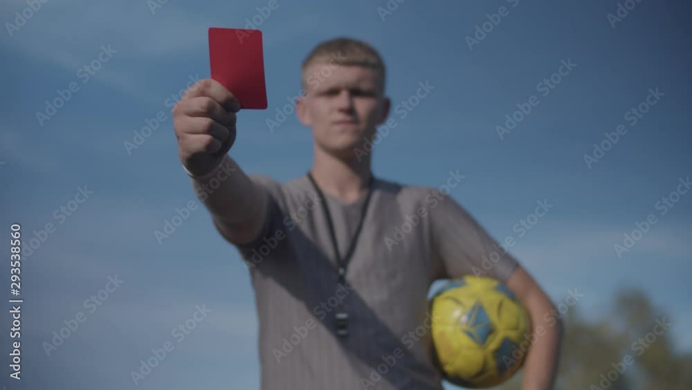 Strict football referee with soccer ball showing red card to send off ...