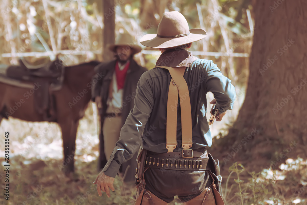cowboy with gun prepares to gunfight. Stock Photo | Adobe Stock