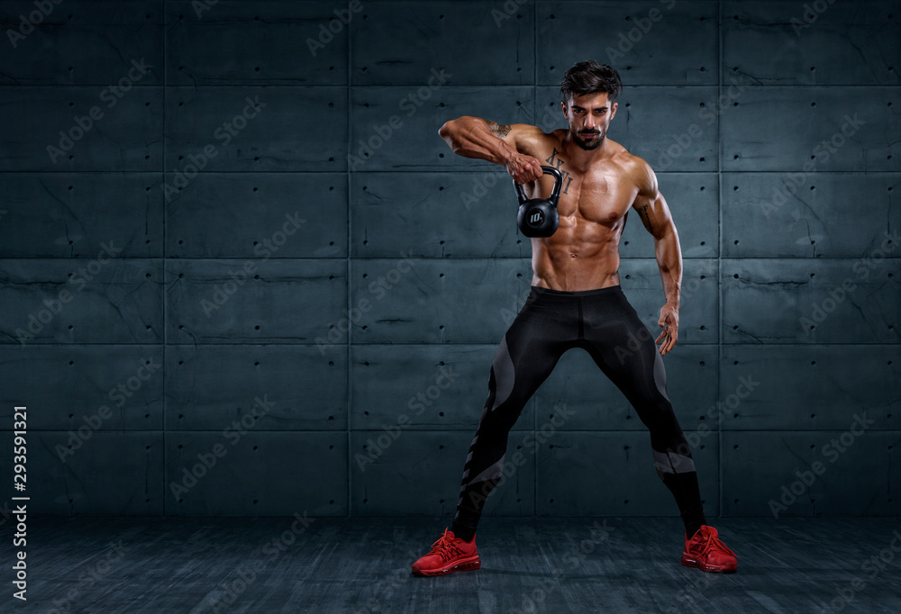 Handsome Bodybuilder Exercising With Kettlebell. Copy Space for text ...