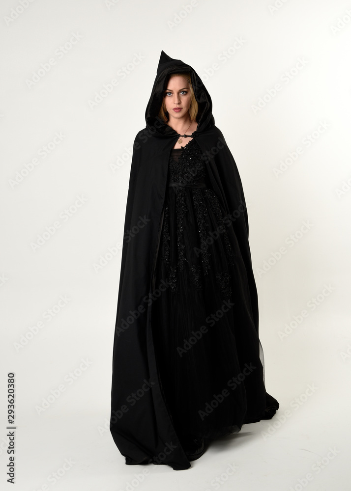 full length portrait of blonde girl wearing long black flowing cloak ...