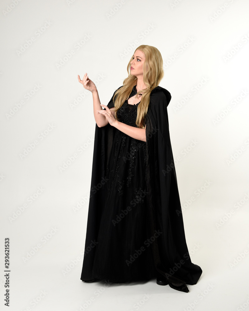full length portrait of blonde girl wearing long black flowing cloak ...