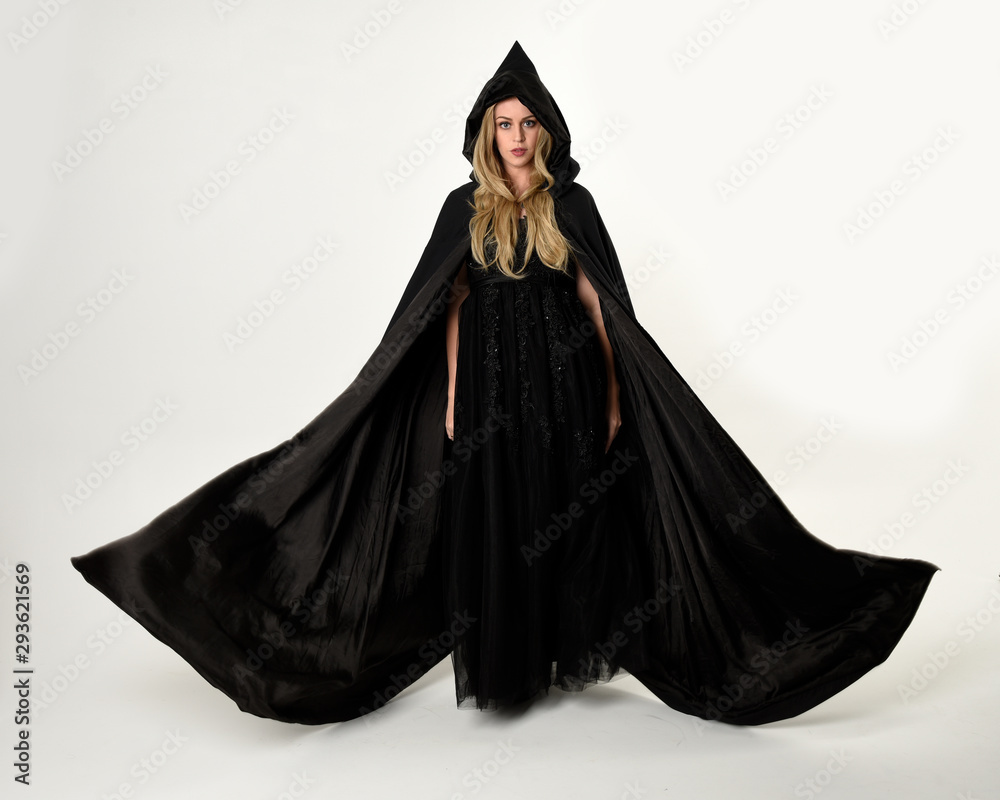 full length portrait of blonde girl wearing long black flowing cloak ...