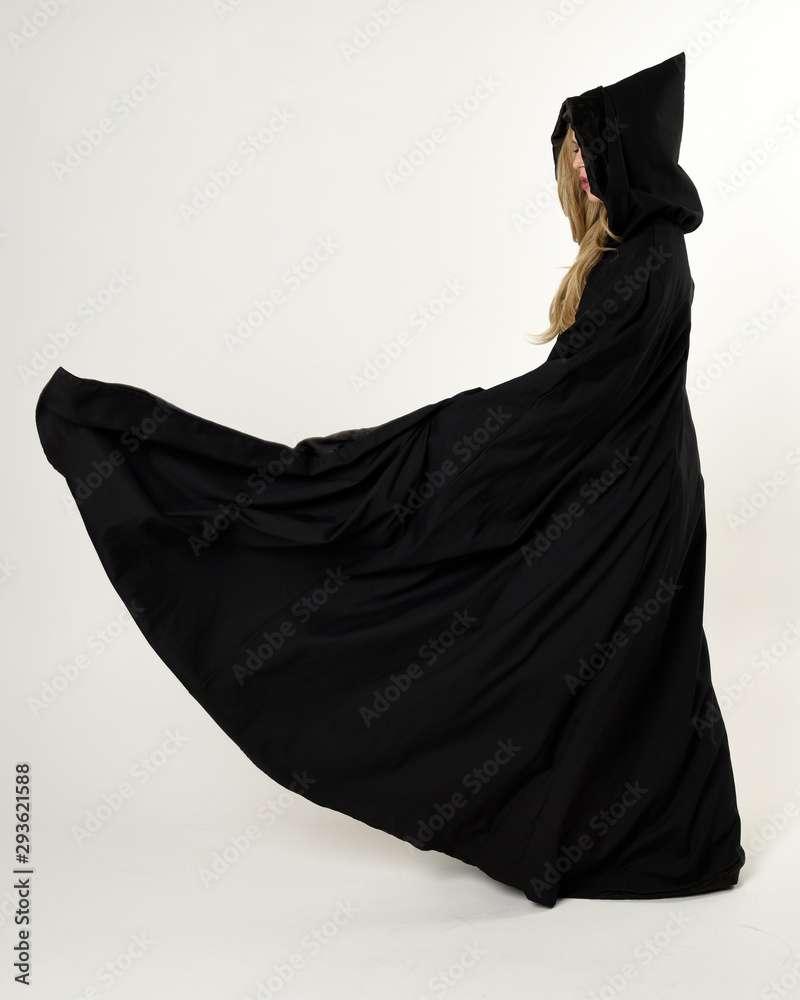 full length portrait of blonde girl wearing long black flowing cloak ...