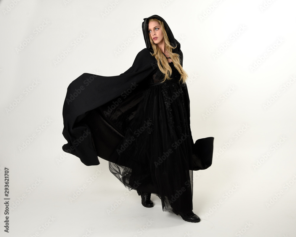 full length portrait of blonde girl wearing long black flowing cloak ...