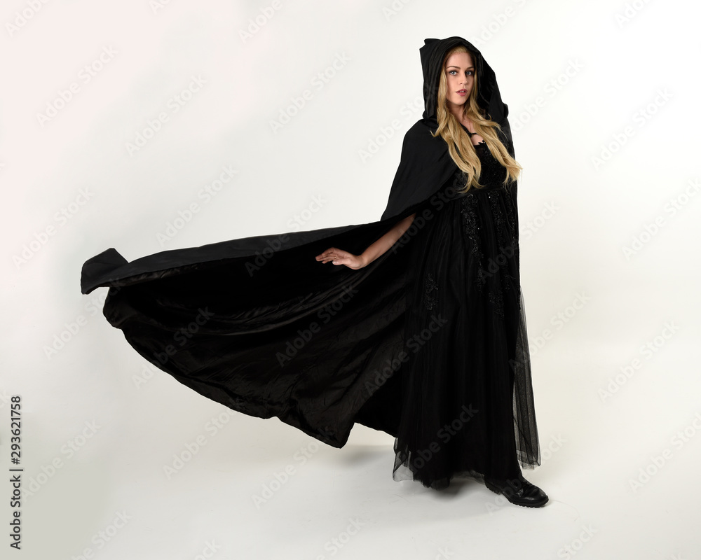 full length portrait of blonde girl wearing long black flowing cloak ...