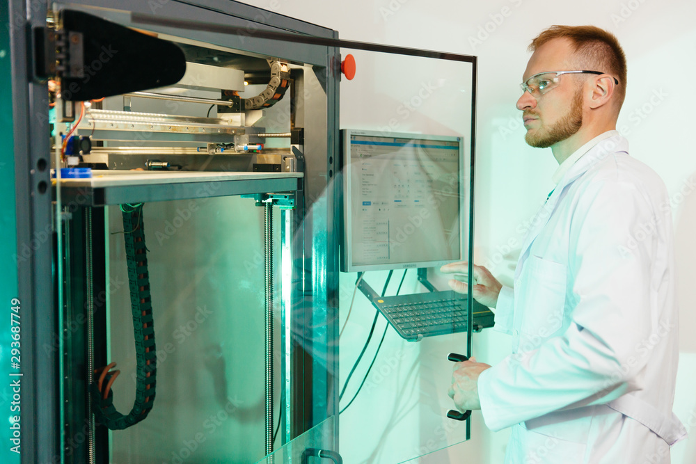 Scientist operates 3d printer Stock Photo | Adobe Stock