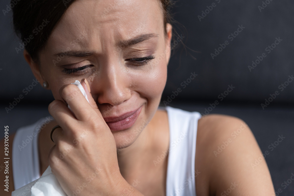 upset young woman crying and wiping tears at home Stock Photo | Adobe Stock