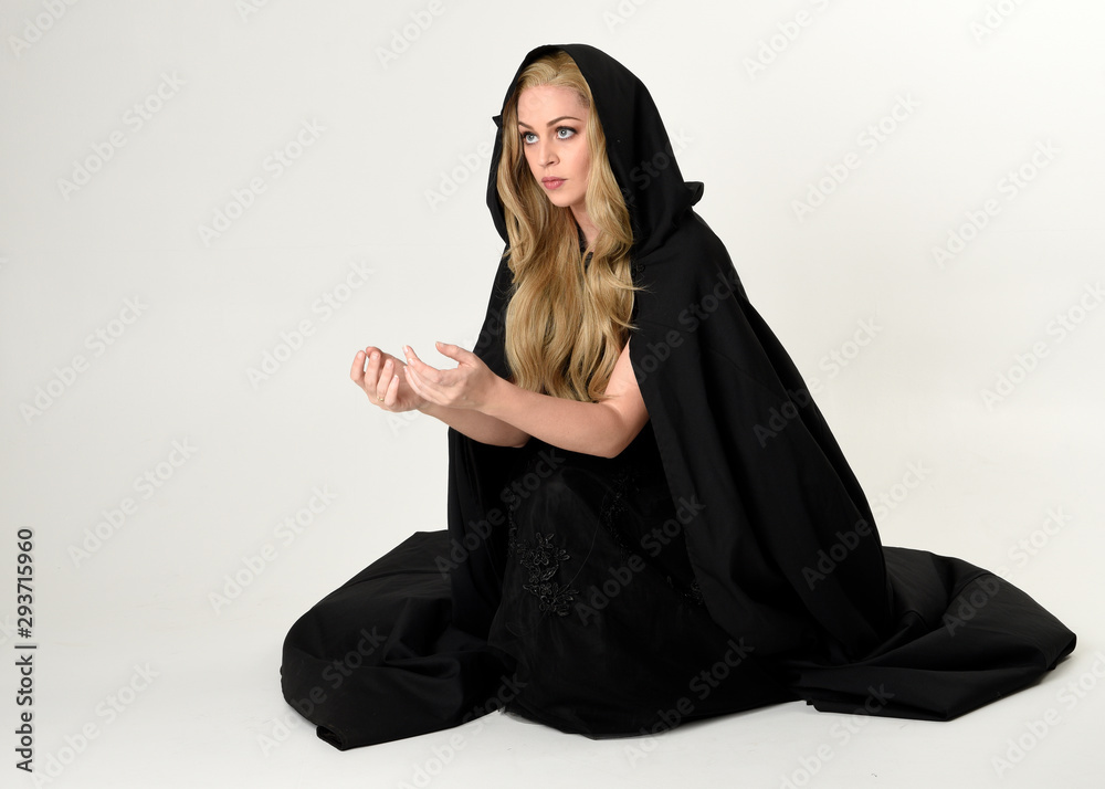 full length portrait of blonde girl wearing long black flowing cloak ...