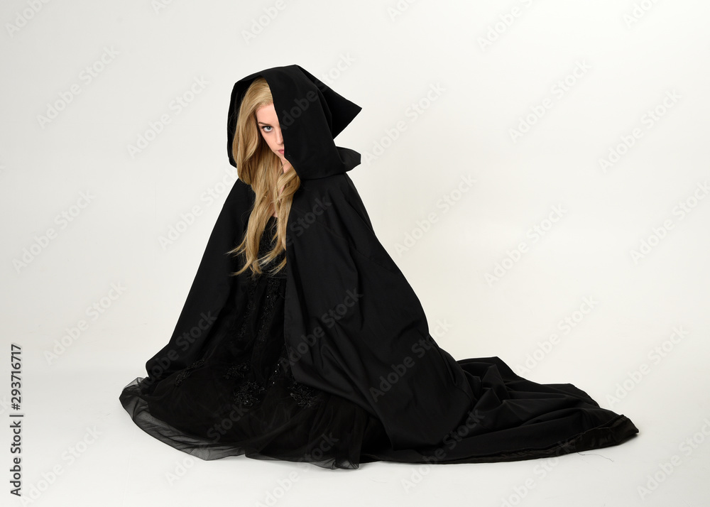 full length portrait of blonde girl wearing long black flowing cloak ...