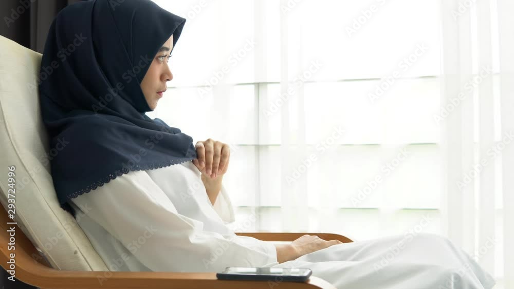 Vidéo Stock Young muslim woman wear hijab sitting on chair in feel sad ...