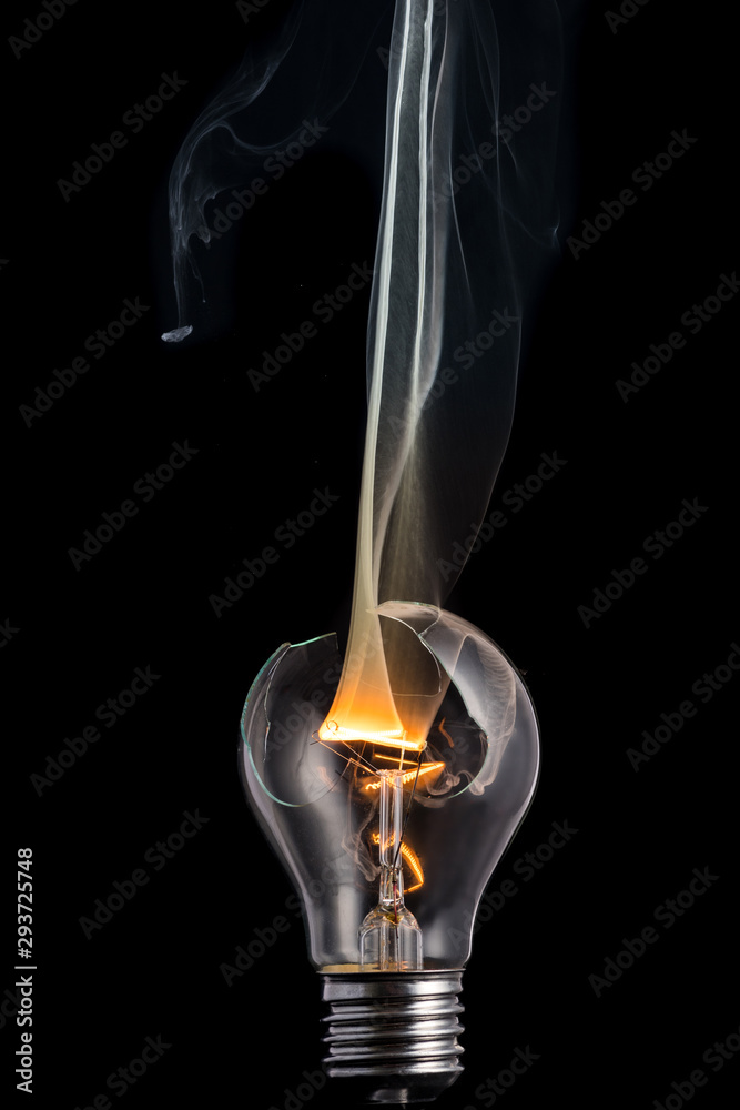 broken light bulb and smoke from a burning spiral on a black background ...