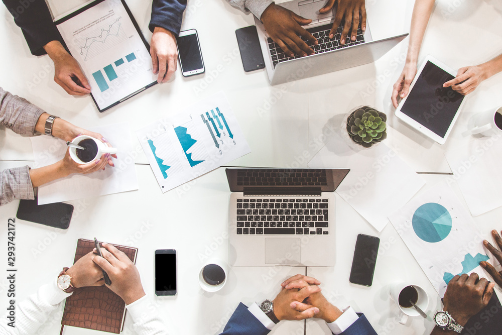 A team of young office workers, businessmen with laptop working at the ...