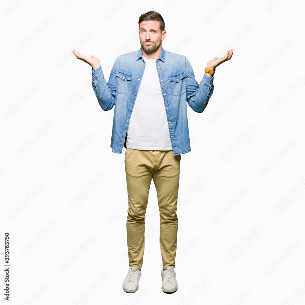 Handsome man with blue eyes and beard wearing denim jacket clueless and ...