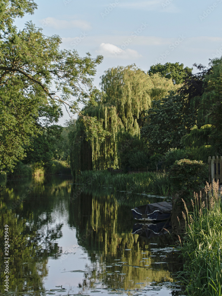 Village back water - a weeping willow a rowing boat and reflections ...