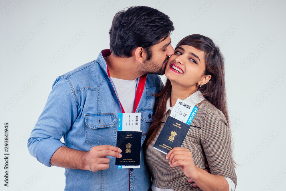 happy indian couple holding passport of India with airline tickets ...