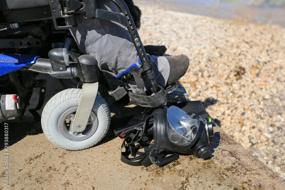 Handicapped disabled scuba diver with equipment on a beach shore ...
