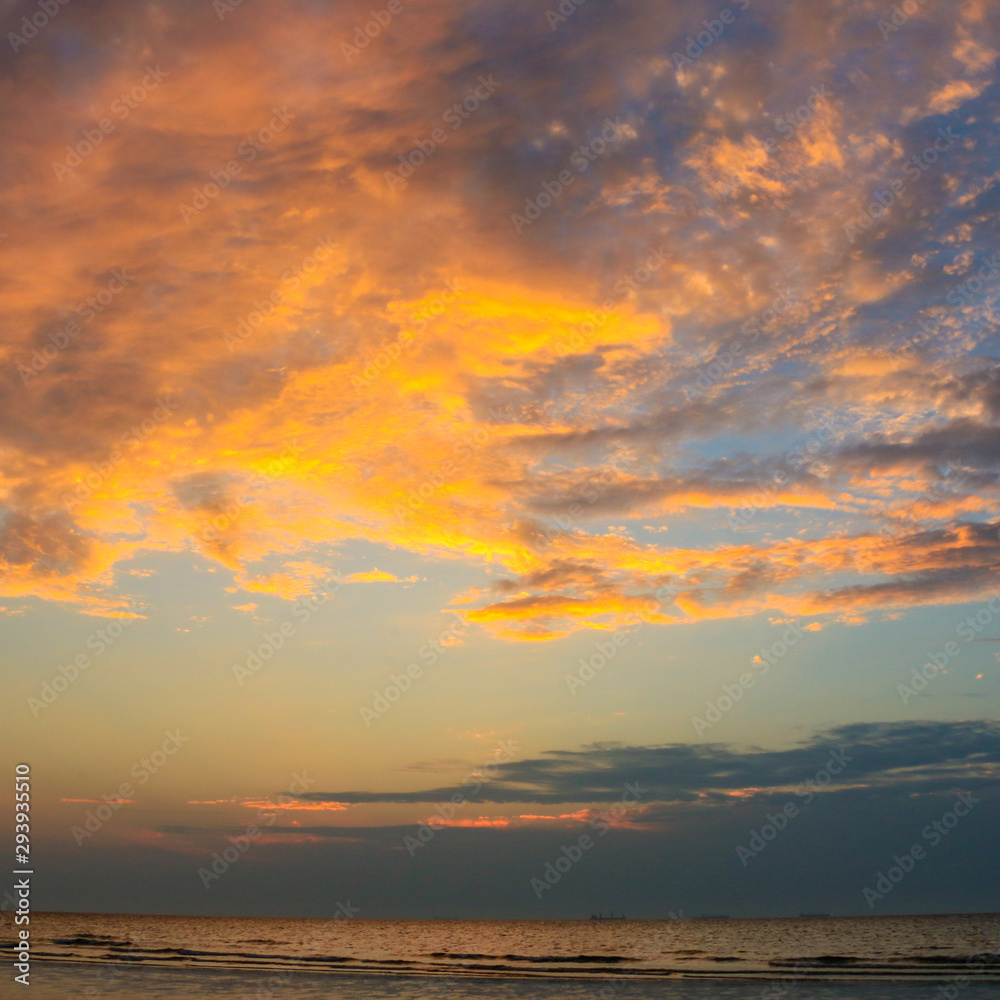 Beautiful golden sunset in the sea with saturated sky and clouds ...