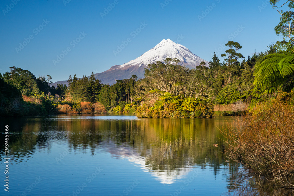 Snow covered Mount Taranaki viewed from Lake Mangamahoe. Also known as ...
