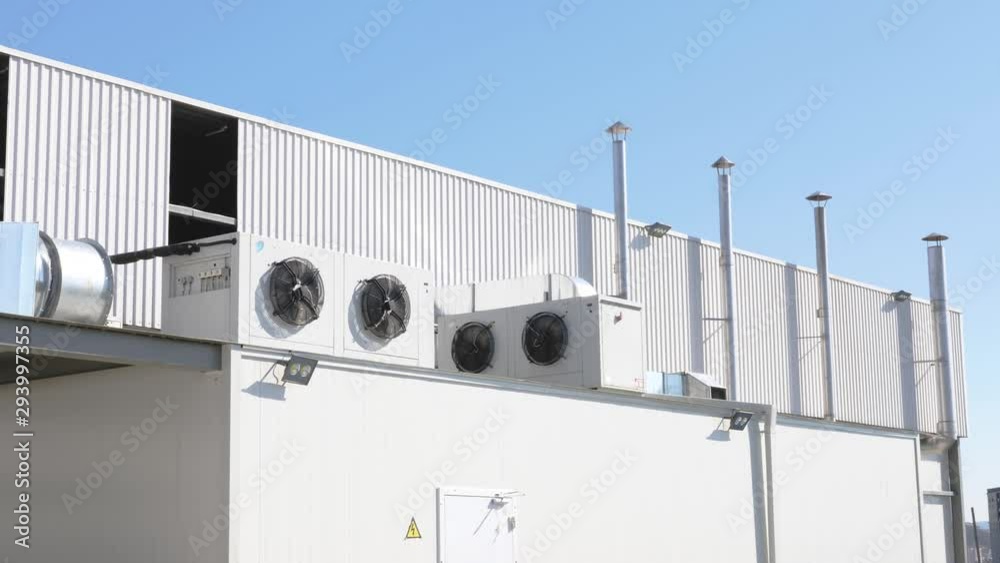 Wall panels with shiny metal chimneys and air conditioner compressors ...