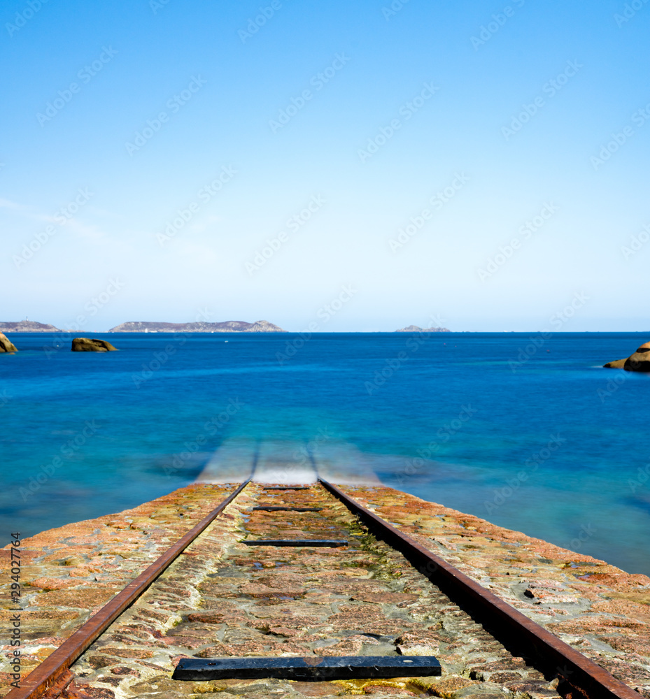 old stone boat ramp for rescue ships leading into a calm blue ocean on ...