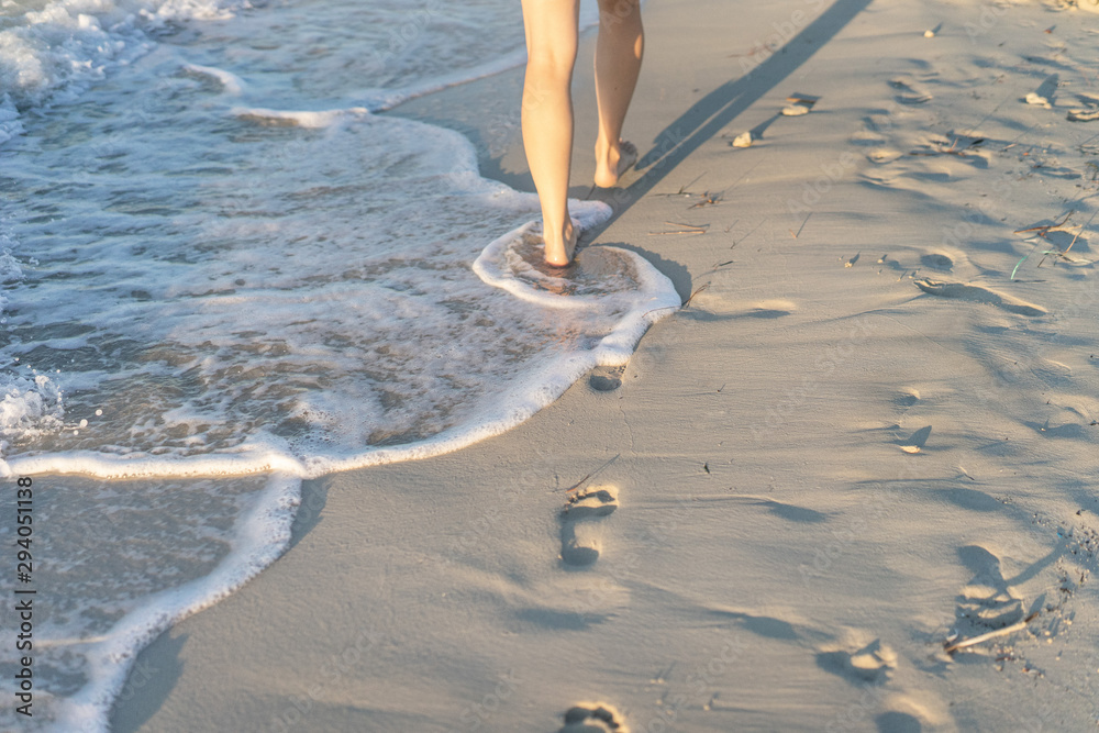 woman walking away on beach Stock Photo | Adobe Stock
