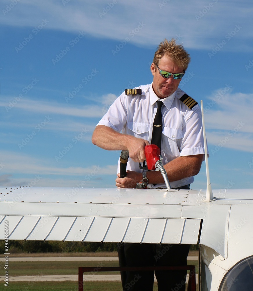 Flight instructor pilot filling the airplane with jet fuel with hair ...