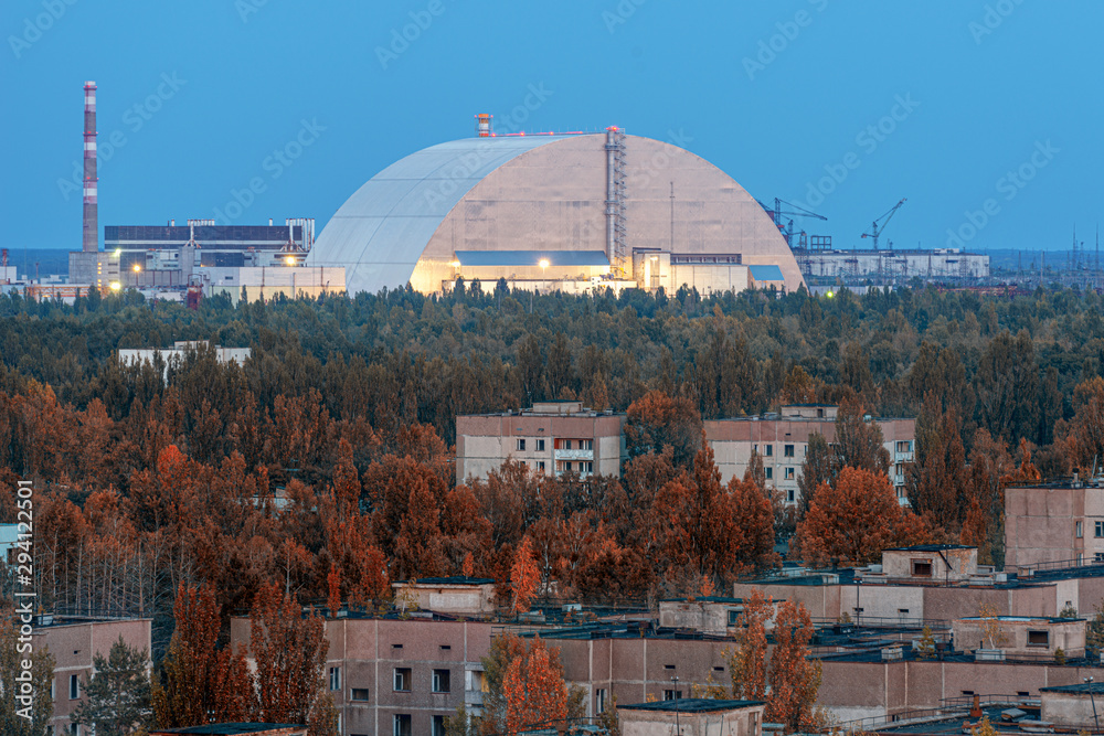view of the new safe confinement arch at evening witn lights of ...