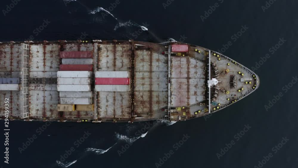 Top aerial view of cargo ship nose with containers on board sailing ...