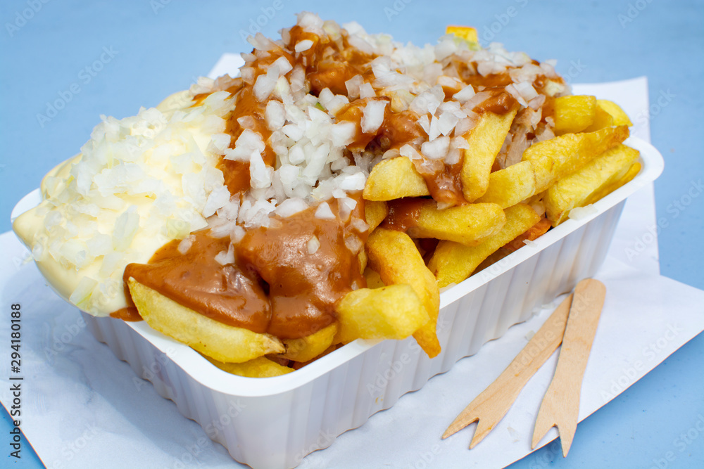 Traditional Dutch fast food dish, fried potatoes with sate sauce, onion ...
